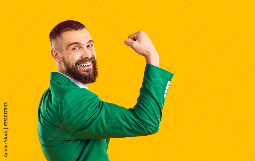 Happy man in suit shows his strong biceps muscles. Cheerful handsome ...