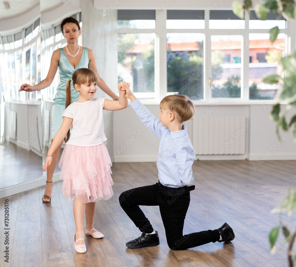 Preteen dancers rehearsing ballroom dance as couple under guidance of ...