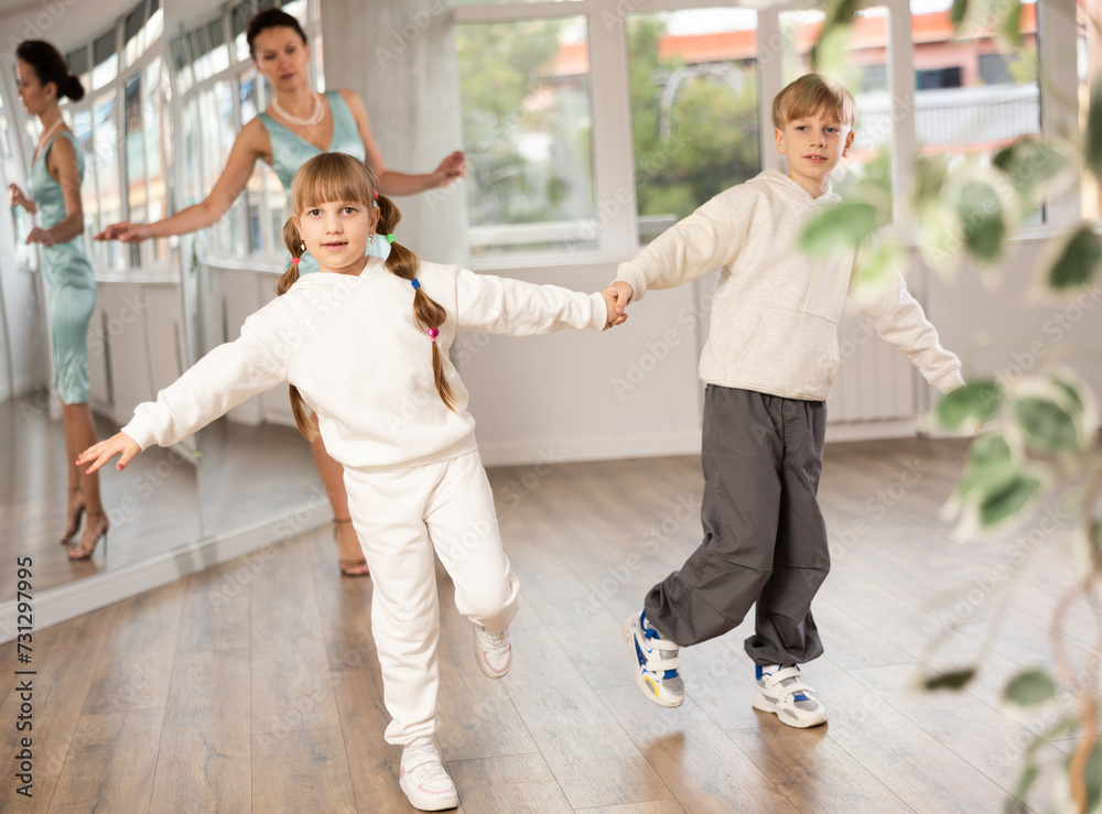 Smiling preteen girl practicing vigorous jitterbug moves with boy ...