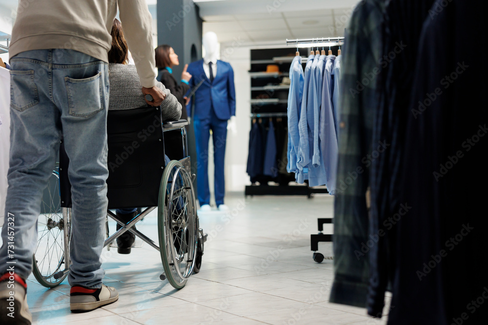 African american woman in wheelchair getting help while shopping for ...