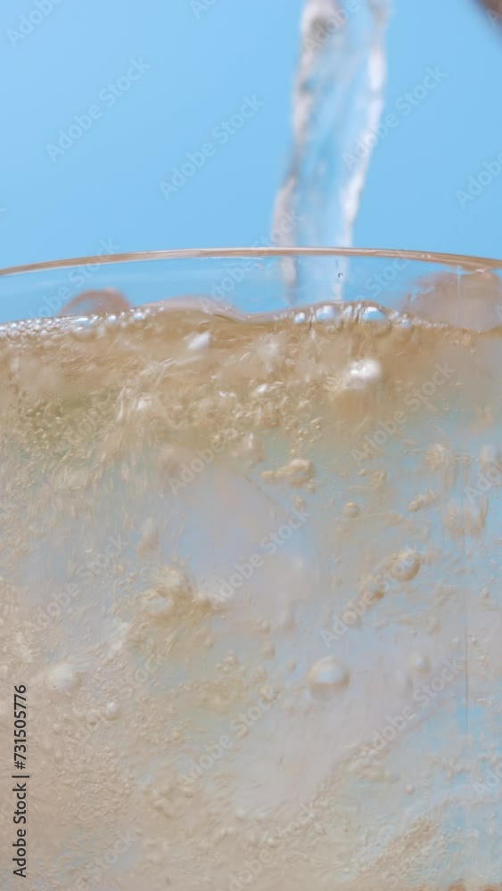 4K footage vertical video Front view SLO MO CU, Pouring soda mixed with ...