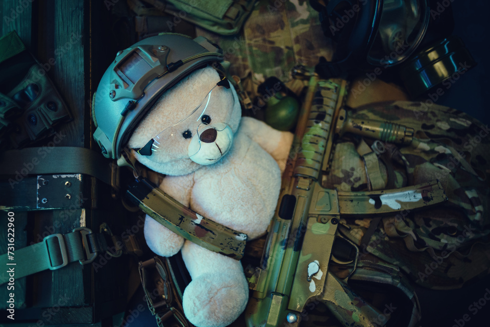 A teddy bear in a military helmet among a pile of military ammunition ...