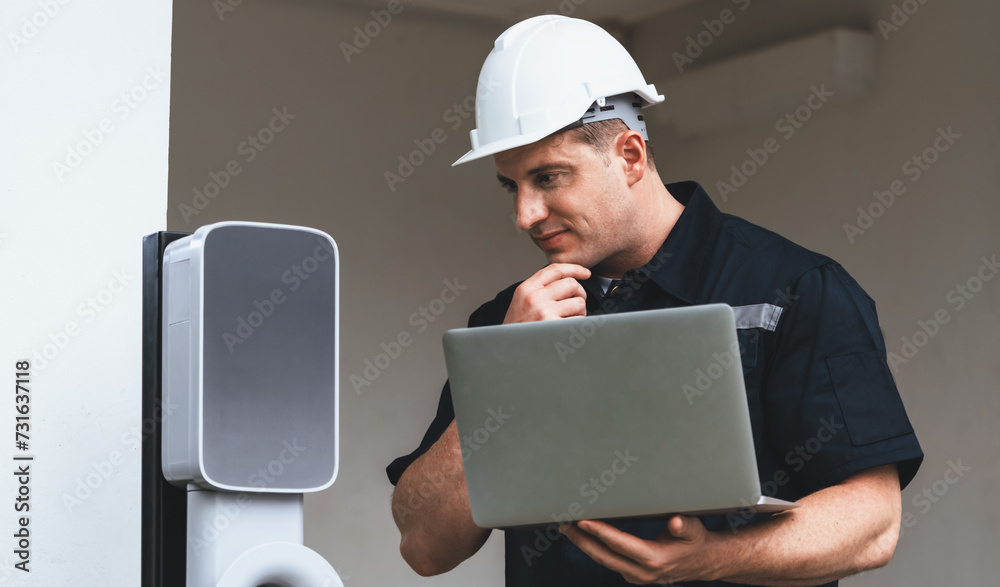 Qualified technician working on home EV charging station installation ...