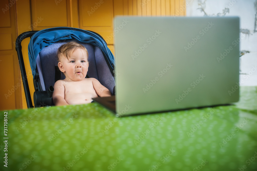 Happy baby boy sitting and watching cartoons on modern wireless ...
