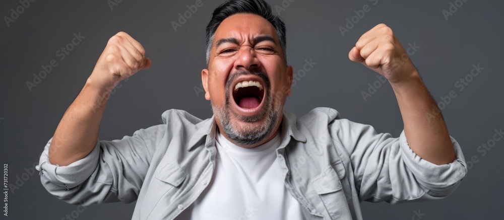 A man with facial hair is shouting and raising his hand in a gesture ...