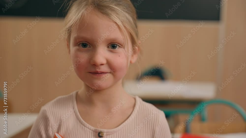 Close up portrait headshot cute little Caucasian girl looking at camera ...
