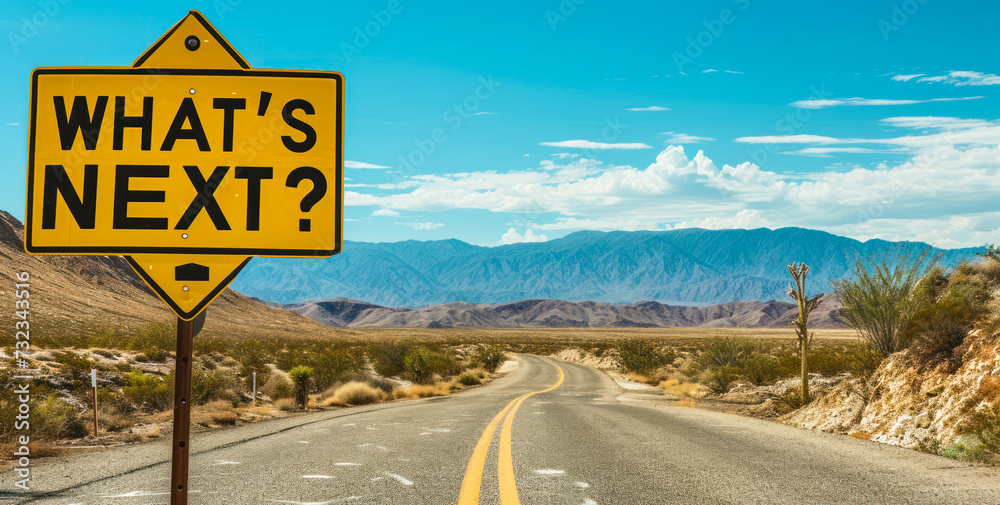 A yellow road sign stands under a clear sky, asking WHAT'S NEXT ...