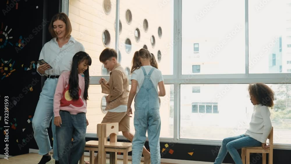 Diverse children playing musical chairs games while young smart ...