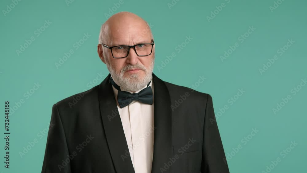Elderly man in formal attire showing disapproval with a stern shake of ...