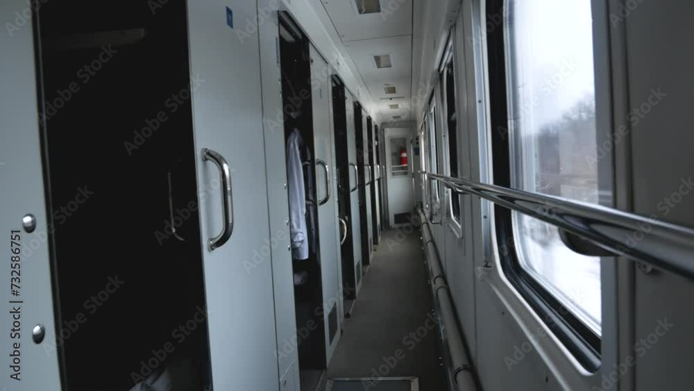 Corridor of a moving train. The compartment doors are ajar in the ...