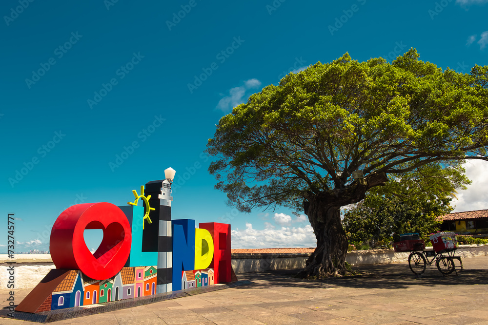Sign of the city of Olinda next to a tree, in Alto da Sé, with the city ...
