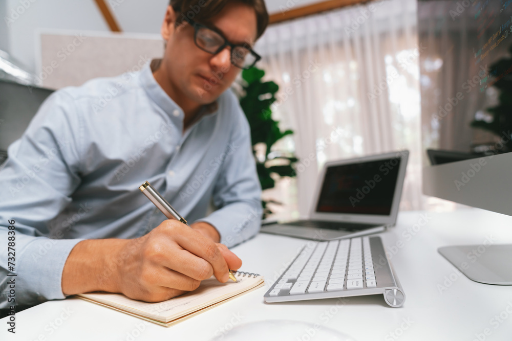 Stressful IT developer analyzing online software development information on pc and laptop with ...