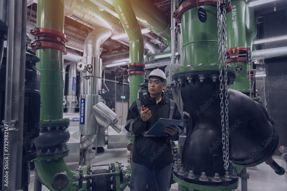 People in Industrial interior chiller and boiler HVAC heating ...