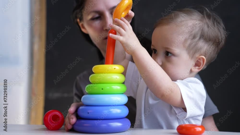 Happy family concept.baby and mother assembling toy pyramid ...