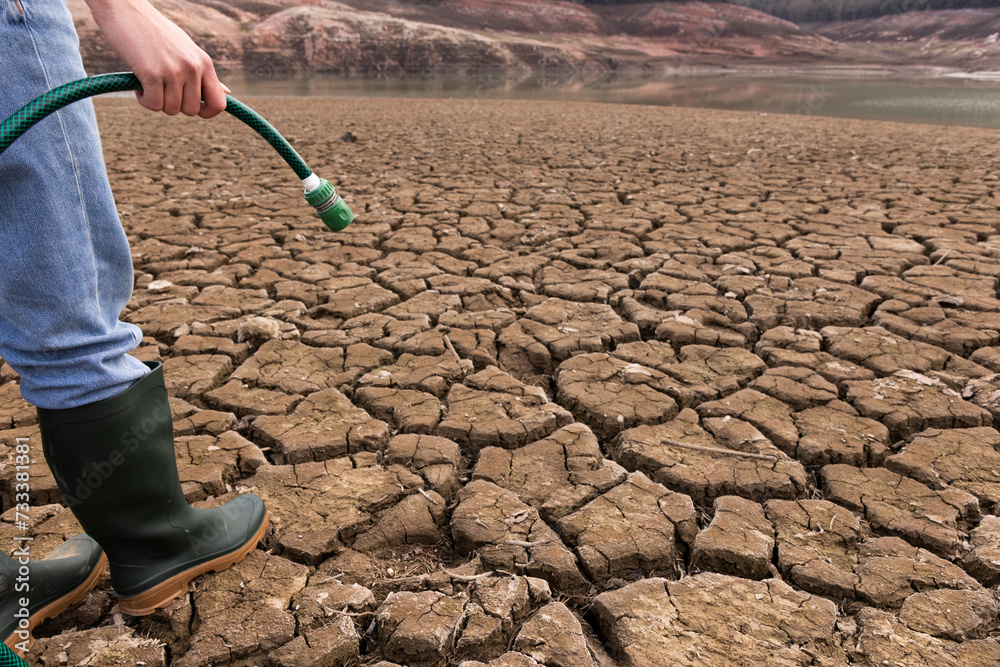Person holding hose People in middle of dry field, weather problems ...