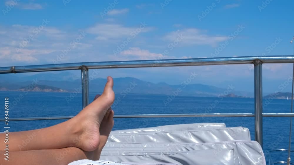 Resting legs on boat deck in sun. A view of bare feet resting on the ...
