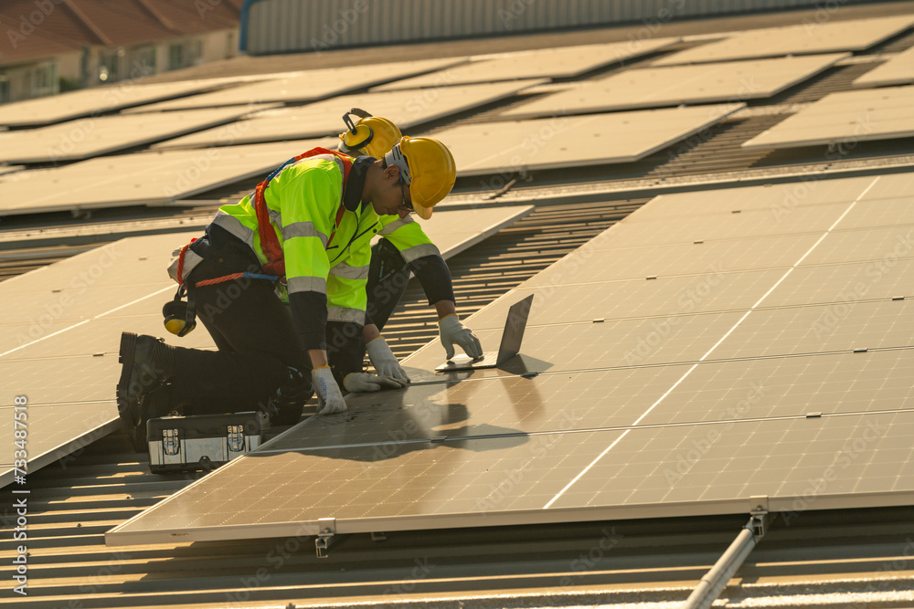 Worker Technicians are working to construct solar panels system on roof ...