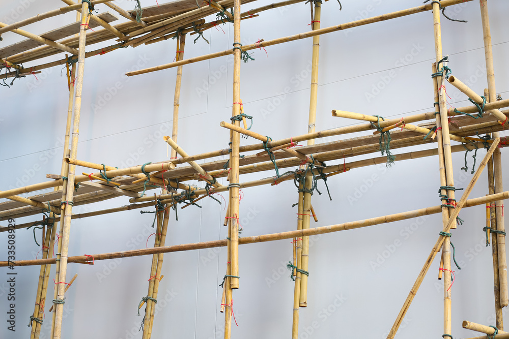 Bamboo scaffolding is installed around the building to support ...