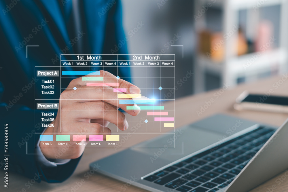 Project manager working on tablet and updating tasks and milestones ...