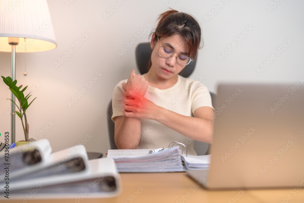 Woman having wrist pain when using laptop computer and mouse during ...