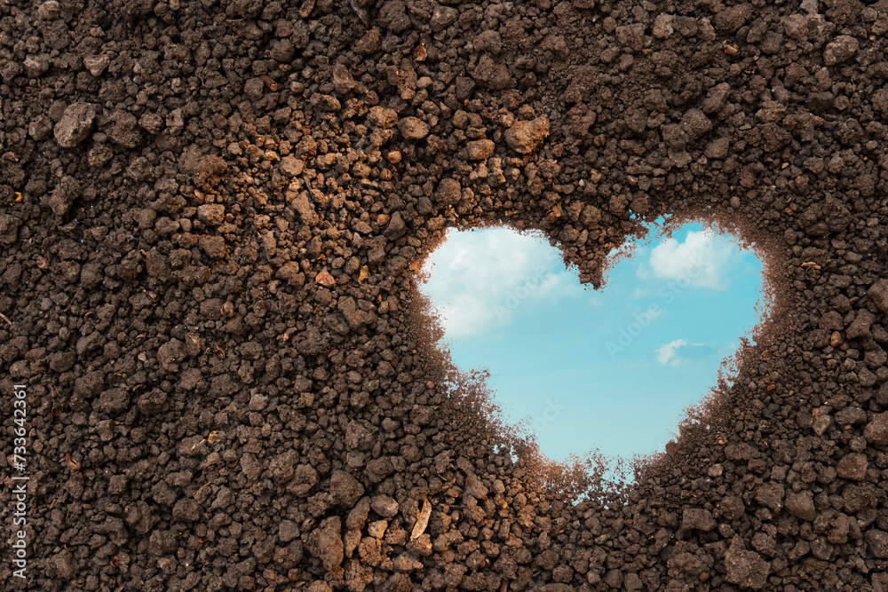 Heart shape reflects the sky in fertile soil. Environmentally friendly ...