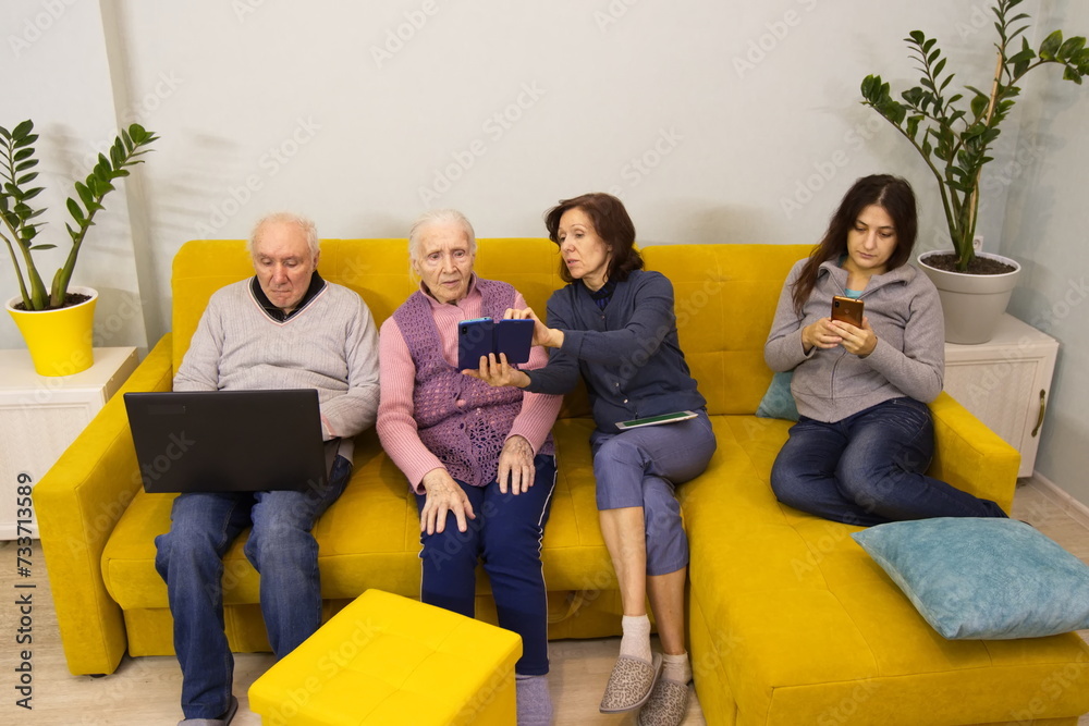 Family members use various electronic portable devices. Grandparents ...