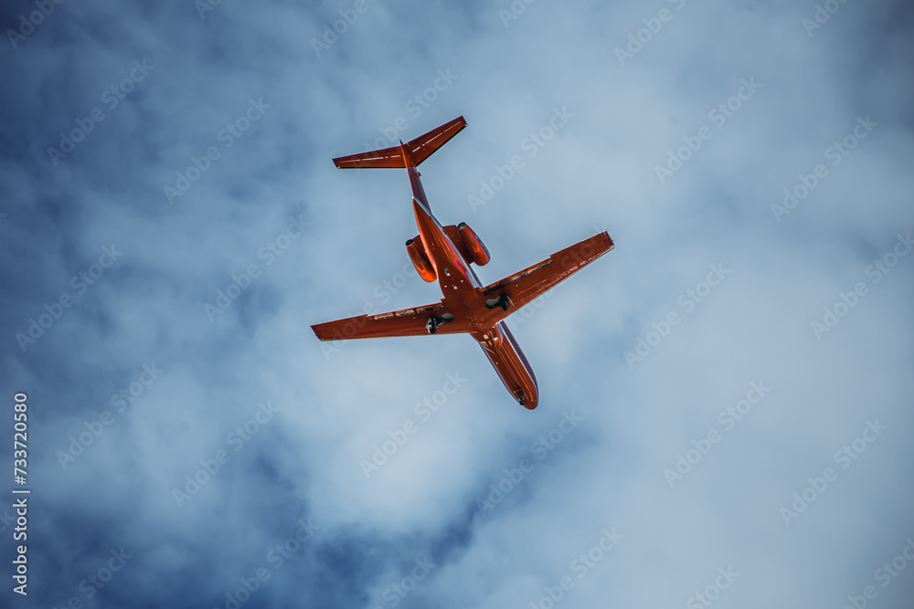Red passenger aircraft in flight. Bottom view of a red passenger plane ...
