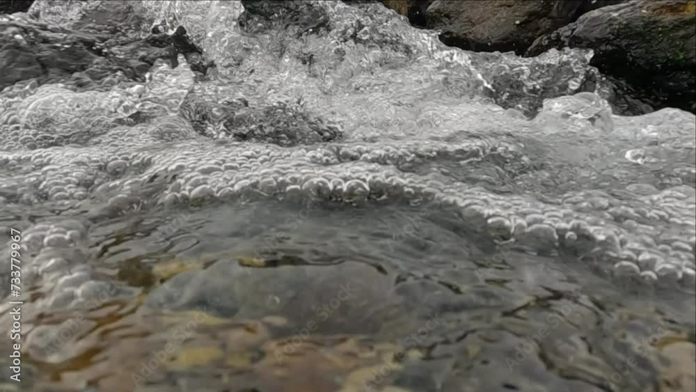 Camera slowly descends on subsurface of mountain river mixed with air ...