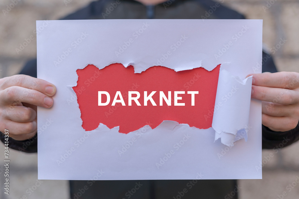 Man holding white and red sheets of paper with text: DARKNET. Darknet ...
