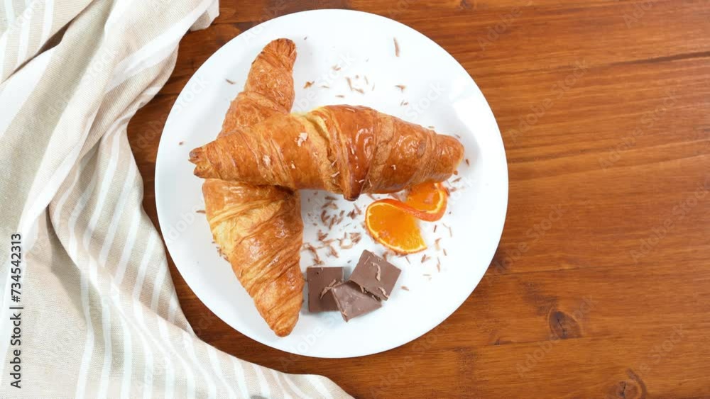 Croissants on a plate decorated with chocolate and fruit and a carafe ...