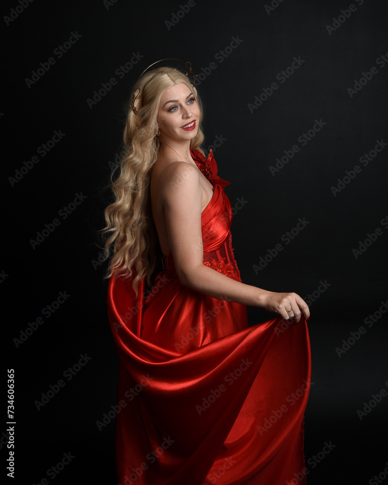 Close up portrait of beautiful blonde model wearing flowing red silk ...