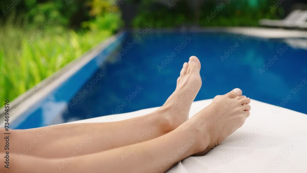 Vidéo Stock Female feet lay by poolside in sunlight, relax by clear ...