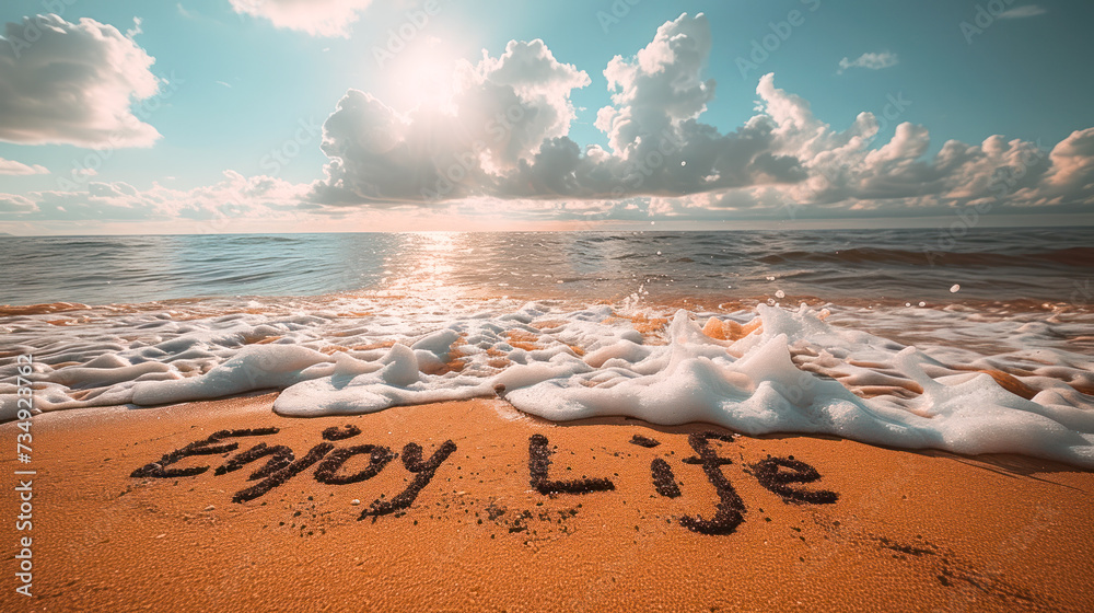 Relaxing summer vibes with Enjoy Life message handwritten in the sand ...