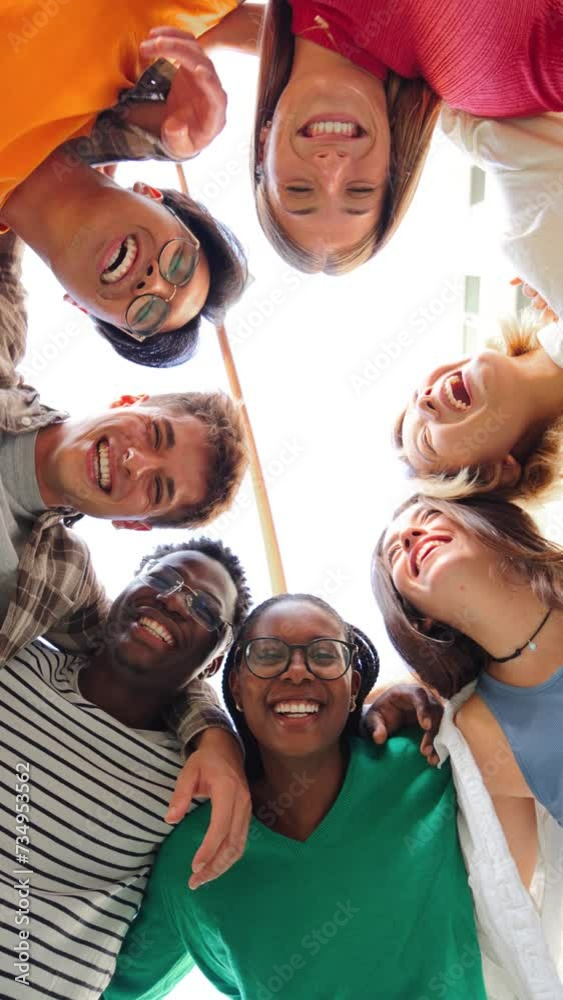 Vertical low angle view of a group of multiracial friends standing on a ...