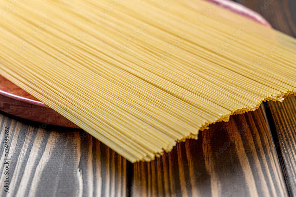 Yellow long spaghetti on a rustic background. Yellow italian pasta ...