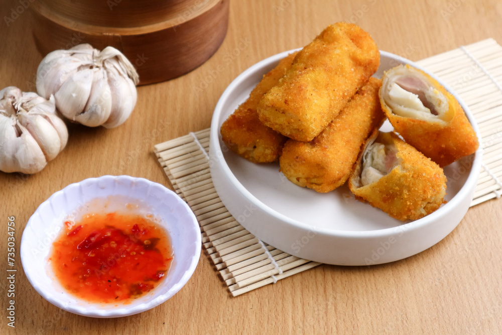 kue risoles mayo (risoles mayo cake) on wooden tray and penaut sauce ...