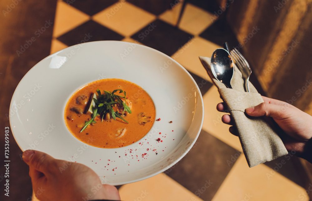 Waiter holding food on hand for serve with chef cooking in the ...