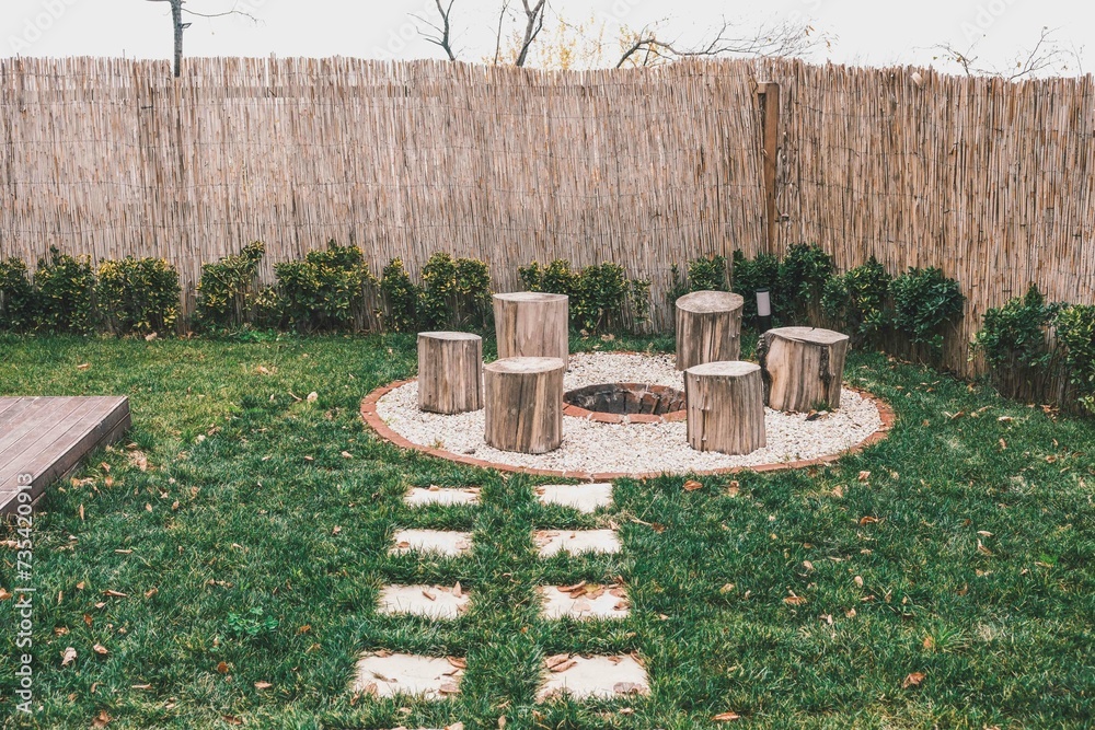 Tree stumps around fire pit with smoke rising from the burning logs ...