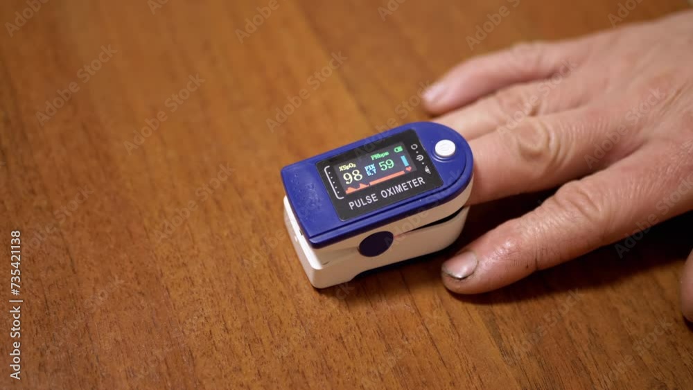 Male Measures Pulse and Oxygen Saturation Using a Pulse Oximeter at ...