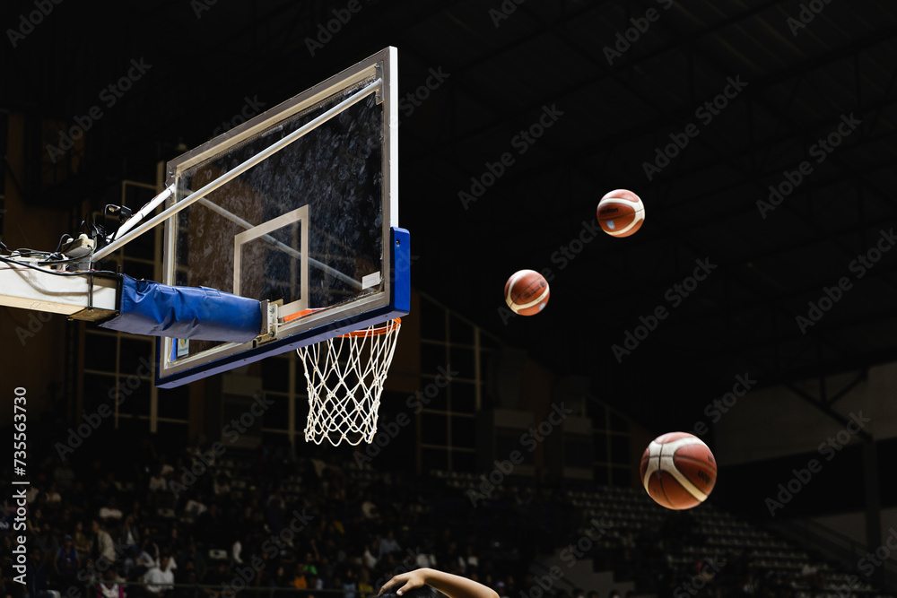 Couple of basketballs thrown into the ring in a basketball arena during ...