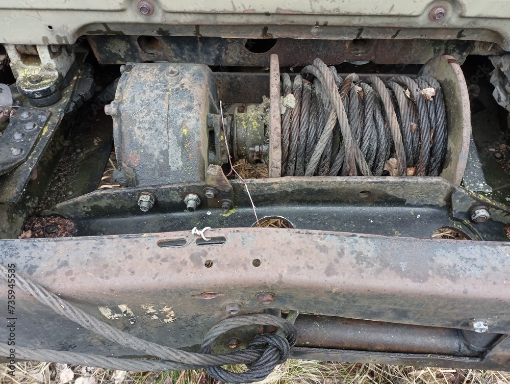 A large winch with a long metal cable is mounted on the front of the ...