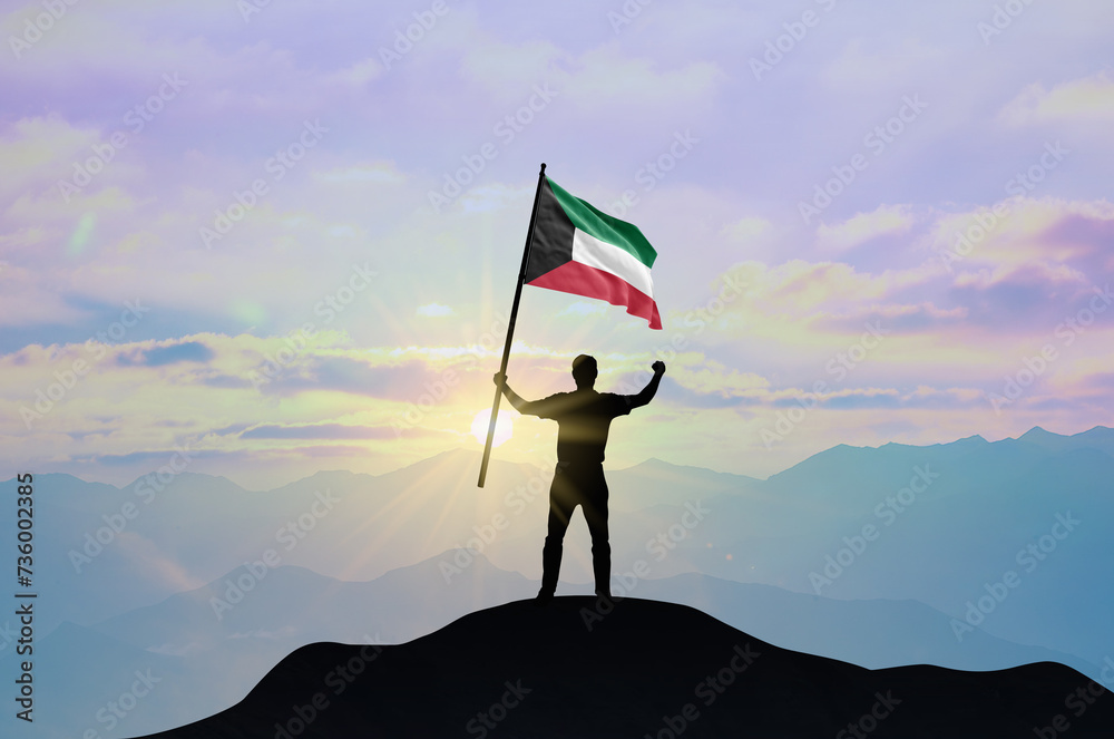 Kuwait flag being waved by a man celebrating success at the top of a ...