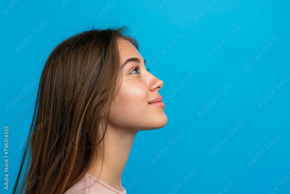 Smiling girl showing advertisement blank area in side profile portrait ...