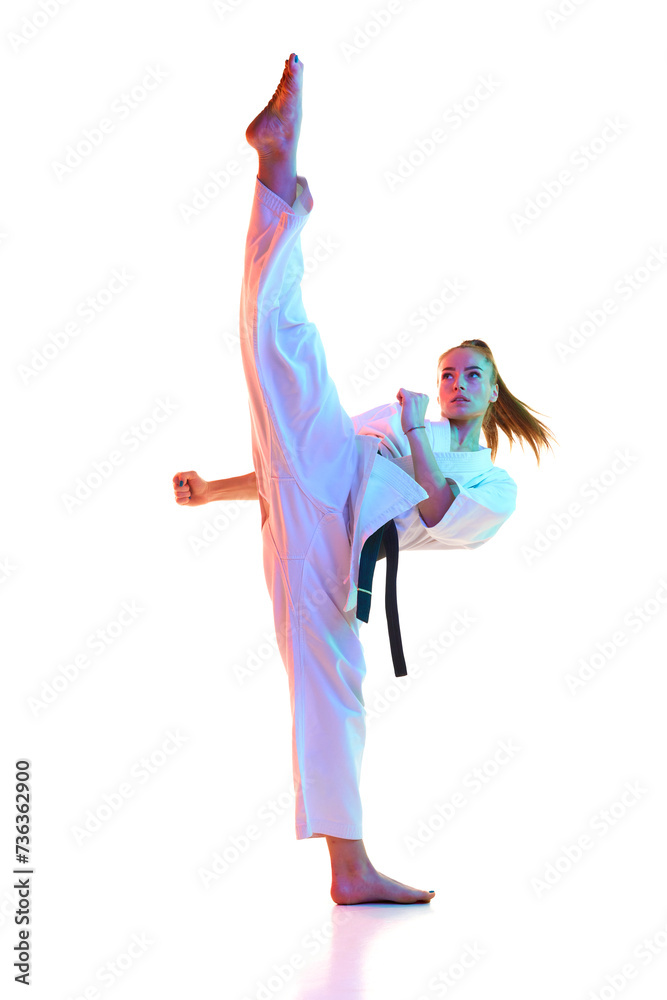 Master black belt Tae Kwon Do fighter in uniform with black belt show high kick pose in neon ...