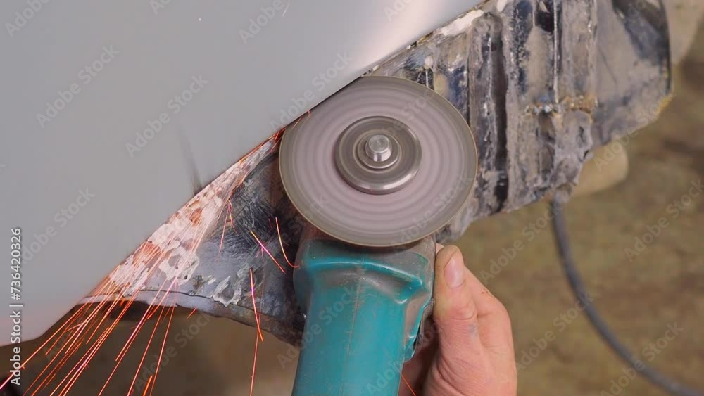 Body shop for car repair, a professional master processes a weld seam ...