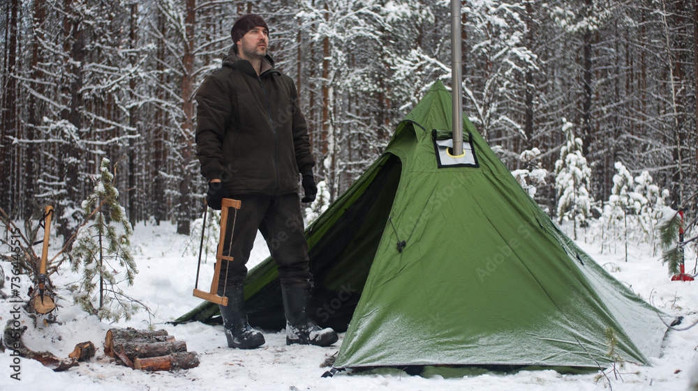 Winter camping in the Boreal Forest. Hot tent. Man stands by a tent ...