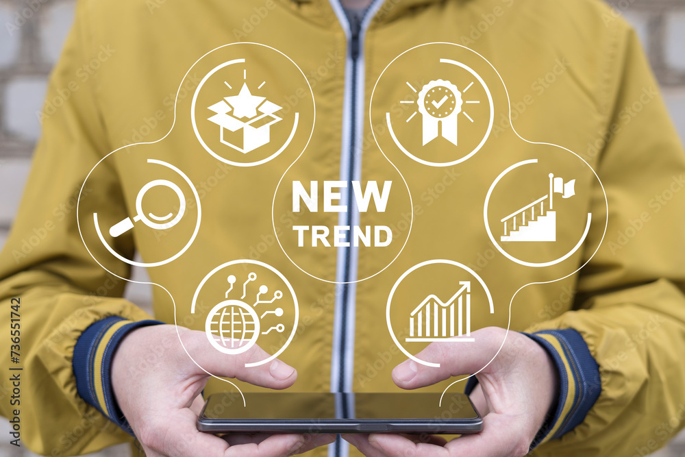 Man holding smartphone and using virtual interface sees text: NEW TREND ...