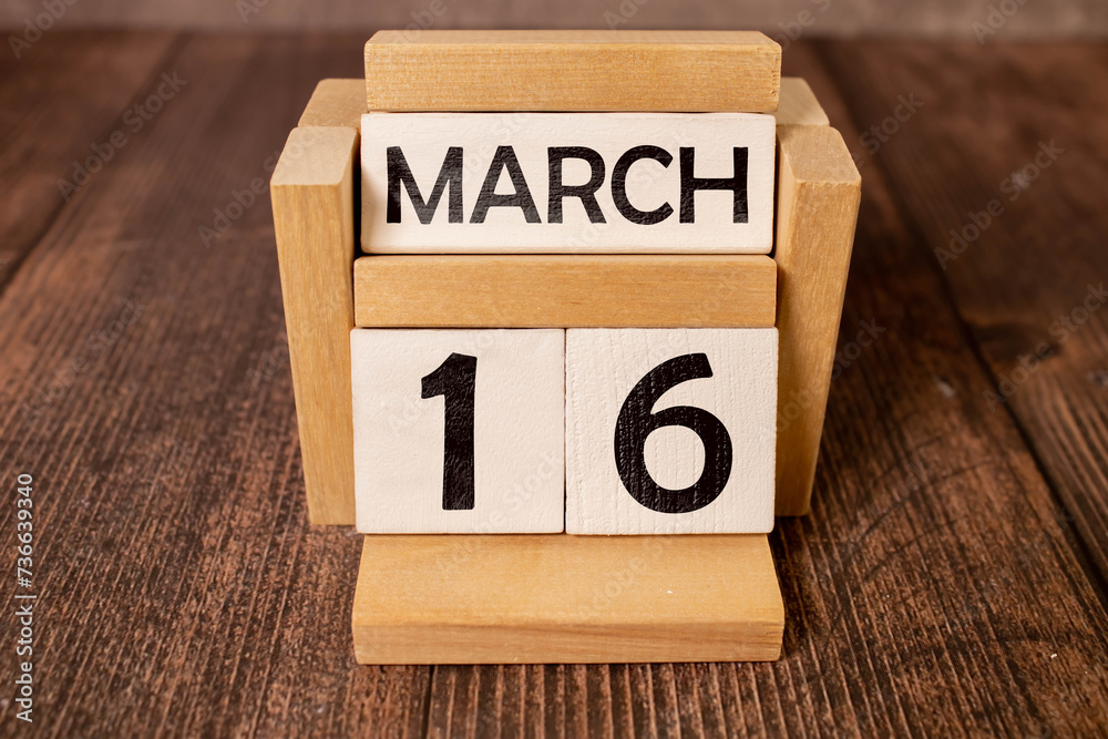March 16 calendar date text on wooden blocks with blurred park ...