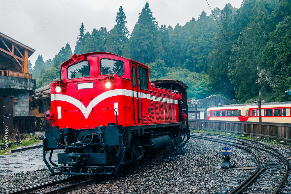 The iconic red train is turning near the station at Alishan National ...