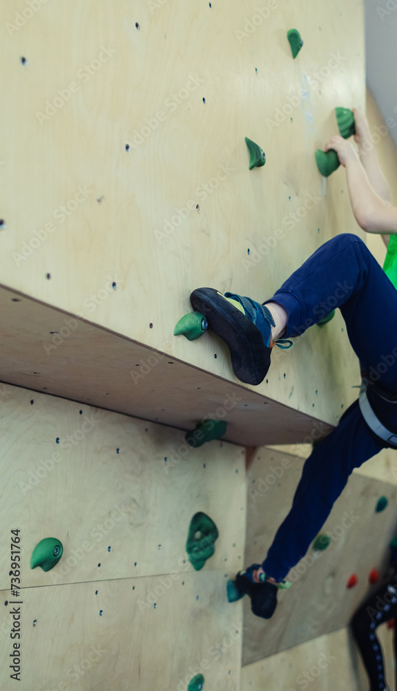 Rock climbing for children. Blond boy in a green shirt is climbing ...